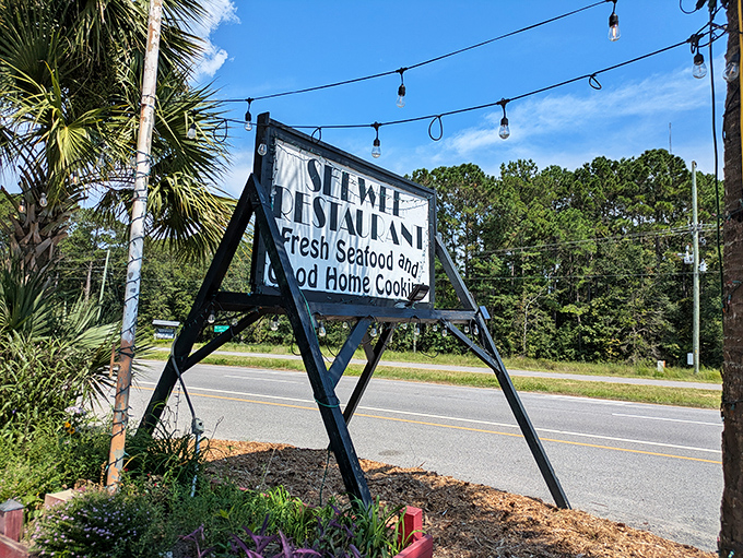 The roadside sign stands as a beacon for hungry travelers. Those string lights aren't just decoration&mdash;they're a signal that you've found your way home.