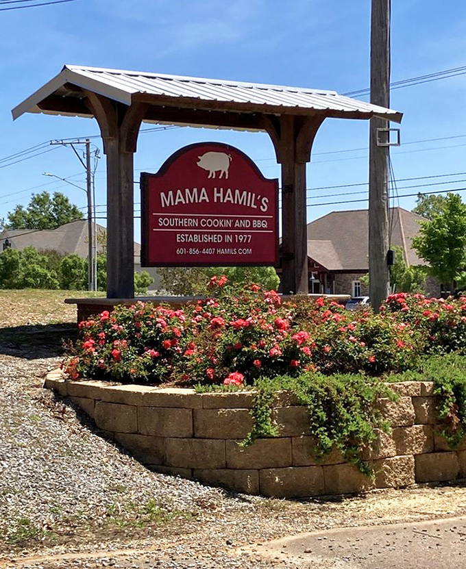 The sign stands like a beacon of hope for hungry travelers&mdash;surrounded by roses as if nature itself is celebrating what awaits inside.