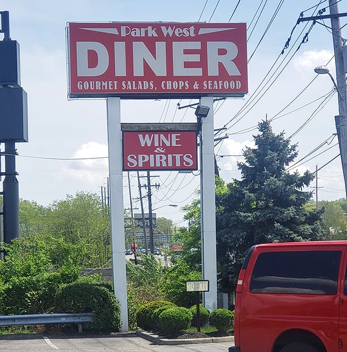The roadside sign stands tall, a red beacon guiding hungry travelers to breakfast salvation just off the highway.