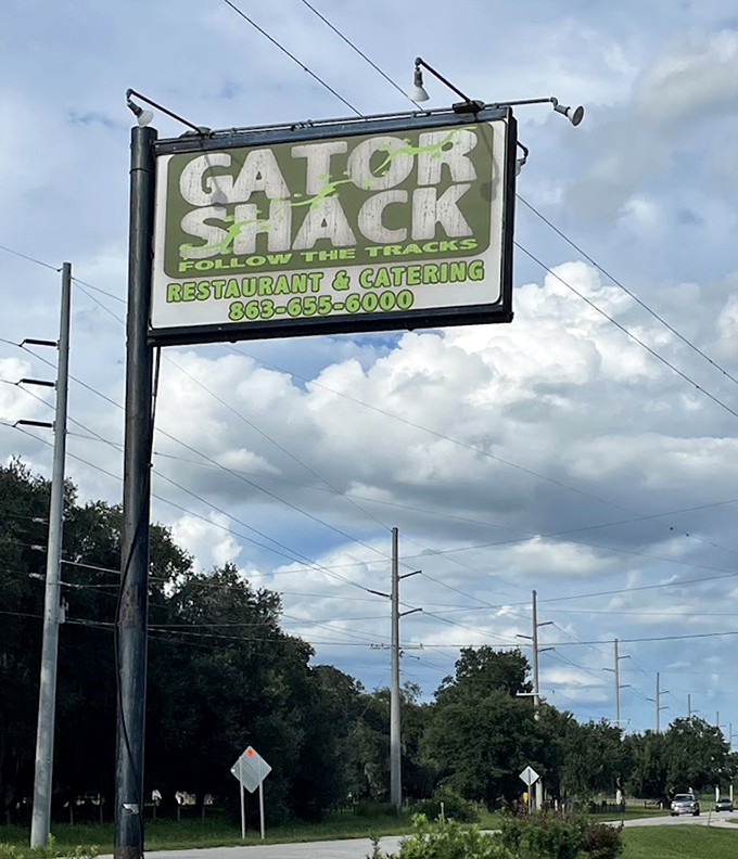 "Follow the tracks" indeed—this roadside sign has guided hungry travelers to flavor paradise for years, standing tall against Florida's ever-changing skyline.