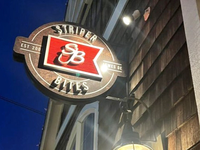 The Striper Bites sign glows like a beacon in the night, guiding hungry travelers to seafood salvation. Follow the light to lobster enlightenment.