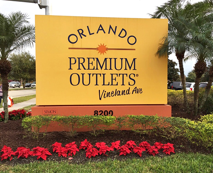 The cheerful entrance sign surrounded by poinsettias&mdash;your first clue that retail therapy of the highest order awaits just beyond.