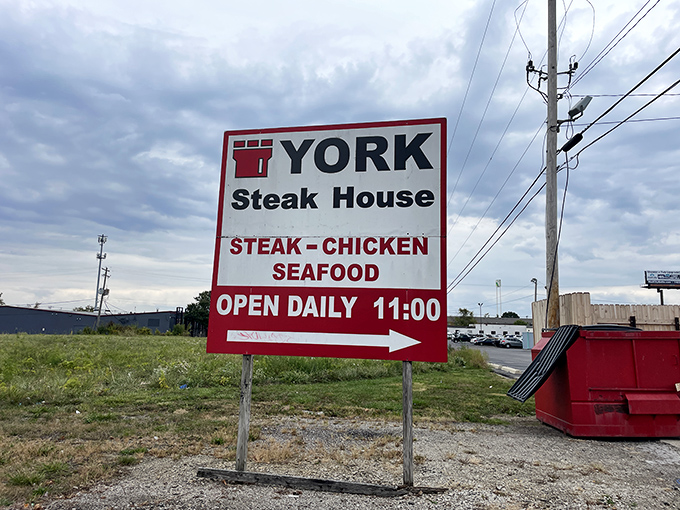 The roadside sign stands like a sentinel of simpler times, promising steak, chicken, and seafood without a hint of pretension or a whiff of foodie buzzwords.