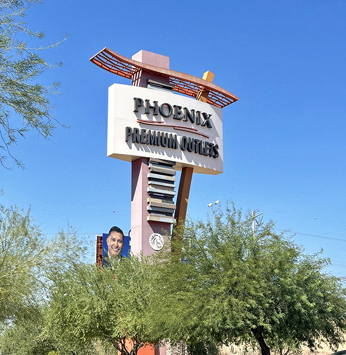 The retro-modern sign announces your arrival at discount paradise, visible from the highway like a beacon of savings.
