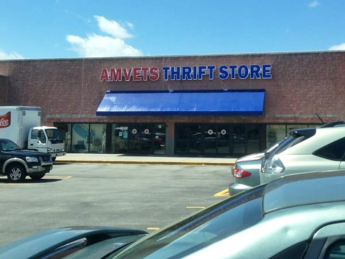 The AMVETS sign glows with promise under blue skies, a landmark for savvy shoppers who know where real retail therapy happens.