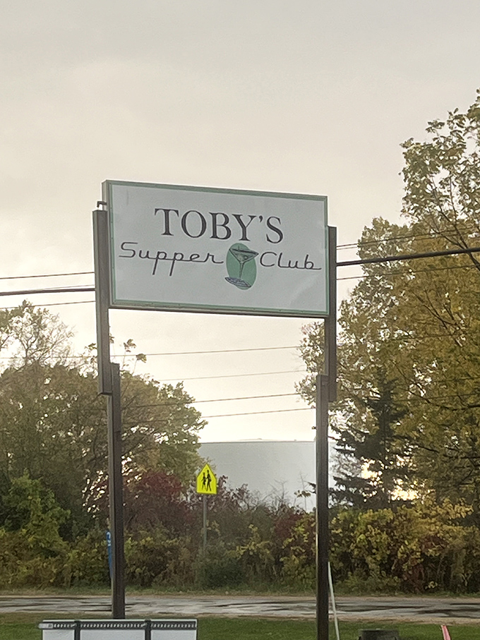 The roadside sign stands as a simple promise—beyond these doors await perfectly mixed cocktails and the kind of meal that makes you plan your next visit before finishing the first.