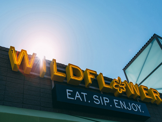 The Wildflower sign glows like a beacon of hope for hungry travelers &ndash; "Eat. Sip. Enjoy." is less a slogan and more a life philosophy.