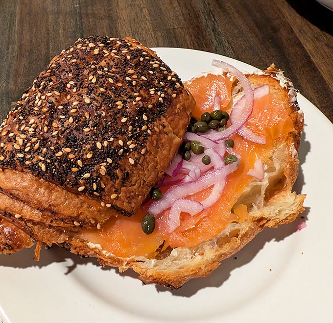 Everything bagel seasoning tops a buttery croissant filled with smoked salmon, capers, and red onions for you to enjoy.