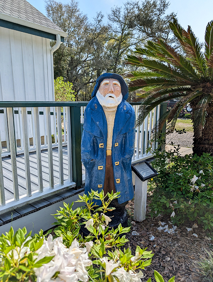 This wooden sea captain stands guard like a nautical garden gnome, silently judging visitors who complain about climbing those 177 stairs.