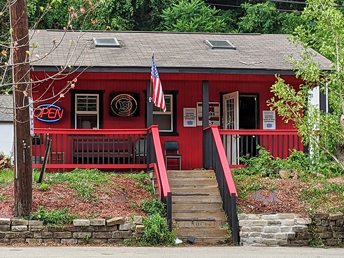 The welcoming front porch says "come on in" while the red exterior promises fiery flavors await inside this unassuming barbecue haven.
