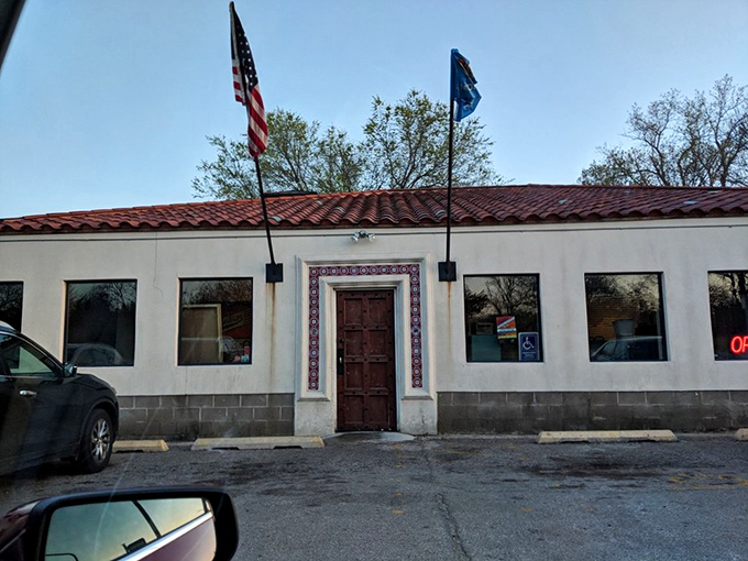 The storefront's Spanish-inspired architecture and twin flags stand as sentinels, guarding the barbecue treasures within like delicious secrets waiting to be shared.