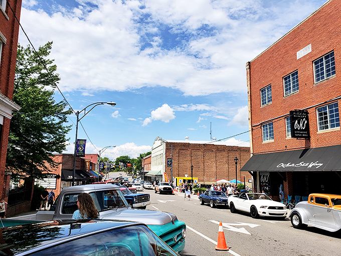 Blue skies frame Mount Airy's bustling Main Street, where classic cars and modern visitors blend in a scene that feels both timeless and surprisingly alive.