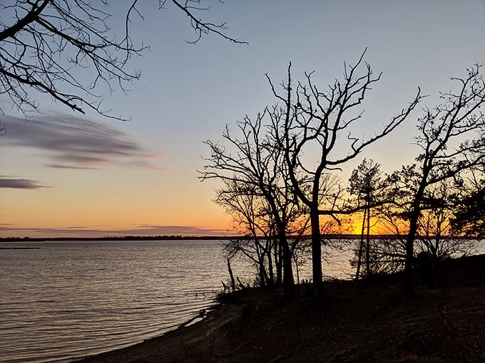 A Kansas sunset paints the sky in golden hues over Elk City Lake, delivering a daily masterpiece that even the wealthiest art collector couldn't purchase.