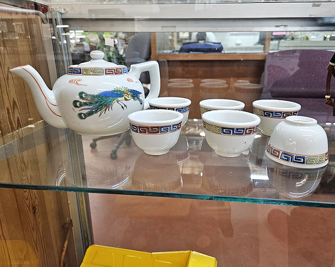 Behind glass, this peacock-adorned tea set waits patiently for someone who appreciates that afternoon tea tastes better when poured from something with history.