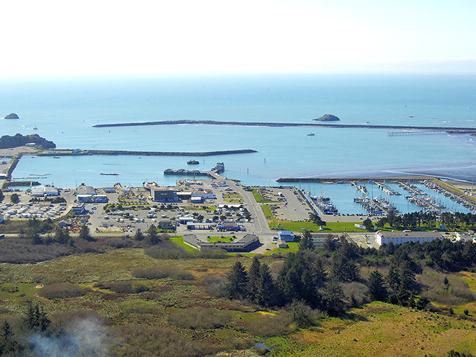 From above, Crescent City's natural harbor reveals its perfect crescent shape. This aerial view shows how the town nestles between forest and sea.