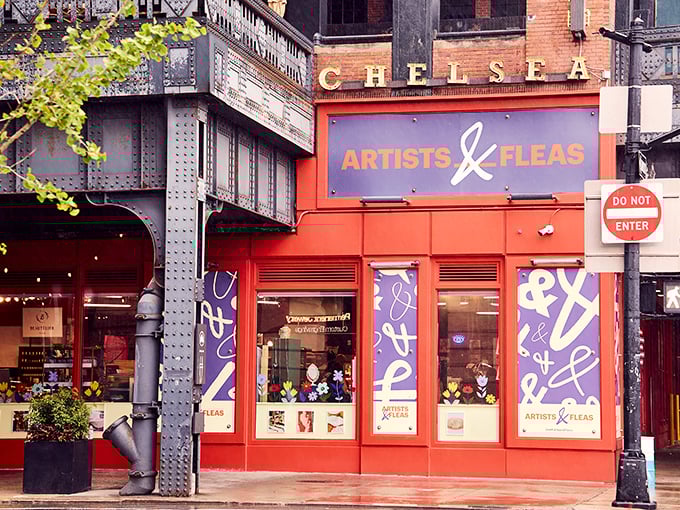 The iconic red storefront of Artists & Fleas Chelsea beckons like a siren call to treasure hunters. Vintage finds await behind those purple-splashed windows!