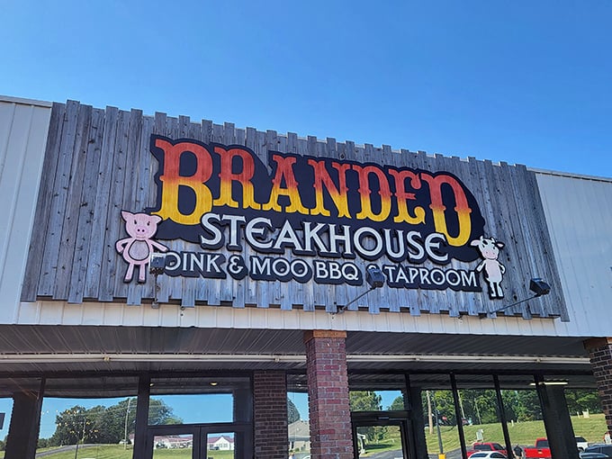 The rustic wooden facade of Branded Steakhouse promises carnivore delights with its playful "Oink & Moo" sign. Meat paradise awaits!