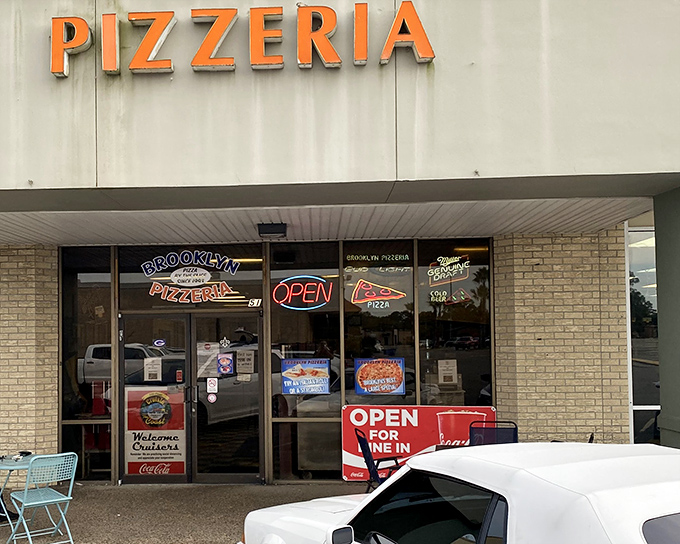 That orange "PIZZERIA" sign glows like a beacon for hungry souls seeking authentic comfort food.