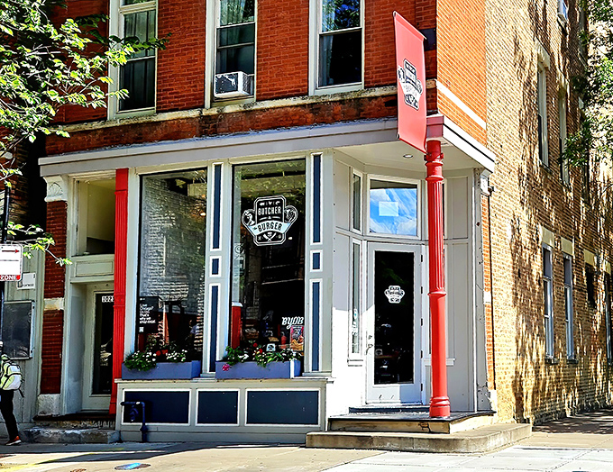 The charming storefront of Butcher & The Burger beckons with its bright red column and classic brick facade. A burger paradise hiding in plain sight!