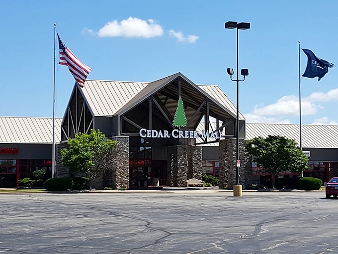 Cedar Creek Mall's welcoming entrance stands proud with its stone facade and iconic green tree logo—shopping paradise awaits behind those doors!