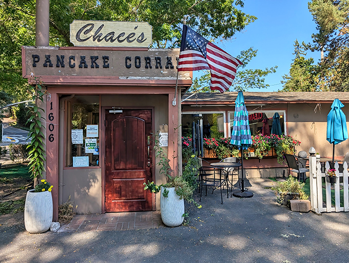 The rustic charm of Chace's Pancake Corral beckons with its wooden facade and American flag &ndash; breakfast paradise awaits!