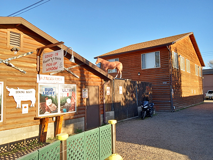 Charlie Clark's rustic log cabin exterior promises cowboy comfort and sizzling steaks. That cow on the wall isn't just decoration&mdash;it's a beacon for beef lovers!