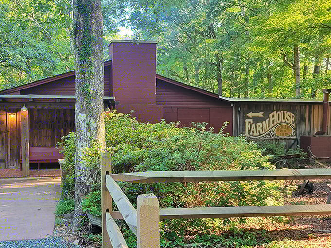 The Farm House Restaurant nestled among trees like a storybook cabin. Country charm awaits behind that wooden fence!