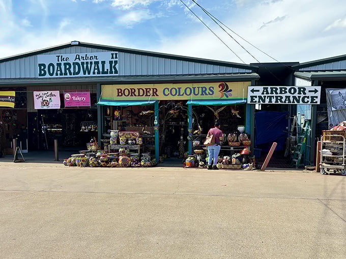 The Arbor Boardwalk entrance beckons with the promise of treasures waiting inside. Border Colours shop displays colorful wares that catch the eye!