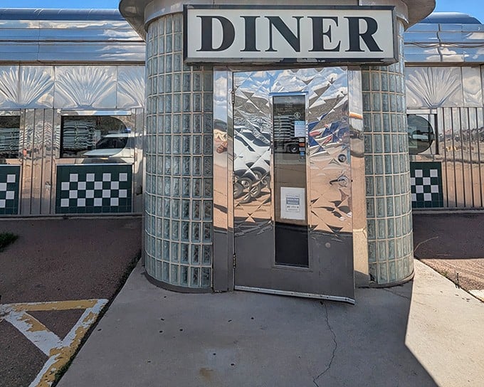 The gleaming chrome entrance of Gabby's Diner beckons like a time portal to the Just try walking past without peeking inside!