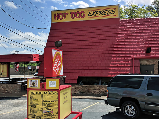 The bright red building of Hot Dog Express stands out like a beacon for hungry travelers. Simple perfection awaits inside!
