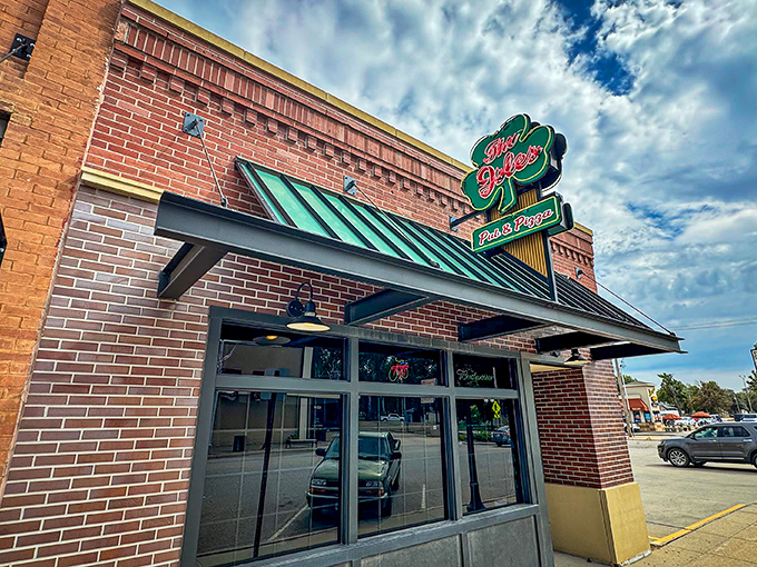 That green awning whispers promises of pizza perfection hiding behind those welcoming glass doors.