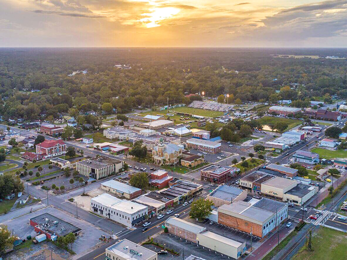 Aerial view of Live Oak at sunset, where small-town charm spreads out like a patchwork quilt beneath the golden Florida sky.