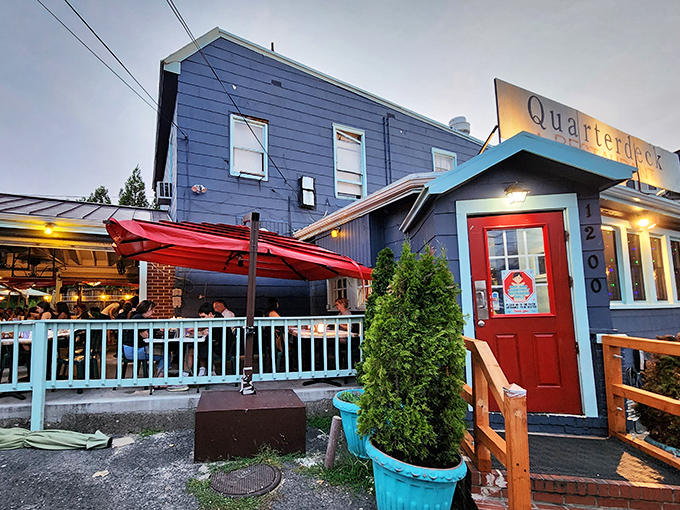 The blue exterior of Quarterdeck with its bright red door looks like a coastal secret that washed ashore in Arlington.