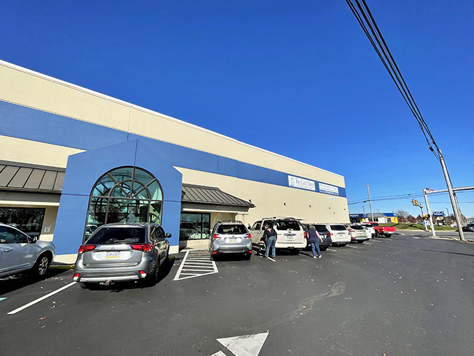 The blue and white facade of Re-Uzit Shop beckons like a calm harbor in a sea of retail chaos.