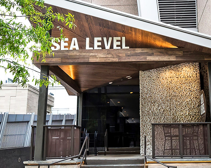 The sleek wooden entrance to Sea Level NC promises an ocean of flavor in the heart of Charlotte's concrete jungle.