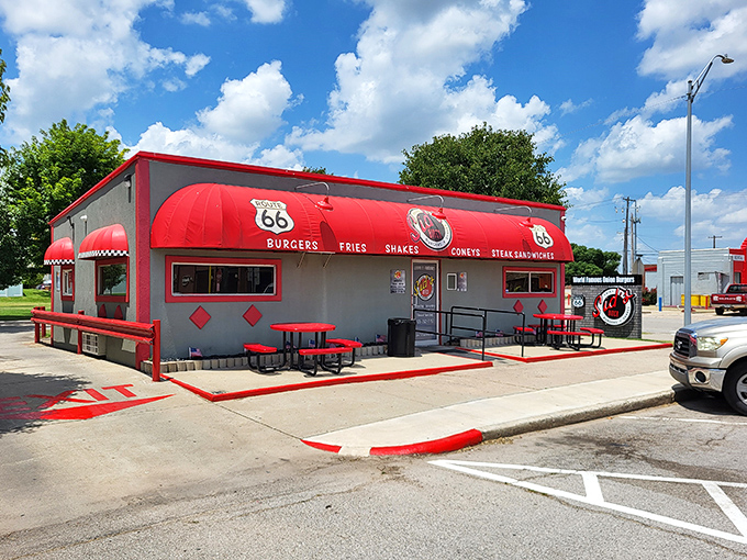 The iconic red awning of Sid's Diner beckons hungry travelers along Route 66 like a burger-scented lighthouse.
