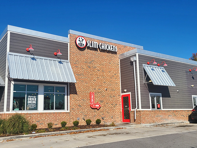 Modern brick meets classic comfort - this Slim Chickens outpost promises crispy perfection behind those welcoming red doors.