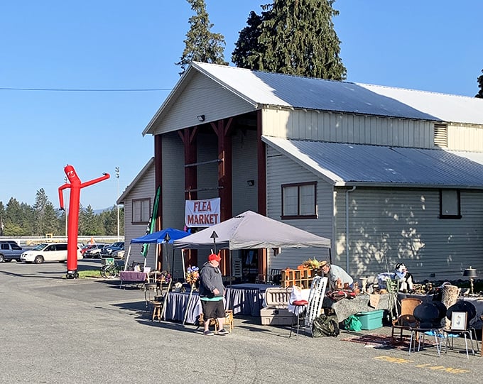 The Southern Oregon Flea Market welcomes bargain hunters with its iconic red tube man, dancing in the breeze like a carnival barker with enthusiasm issues.