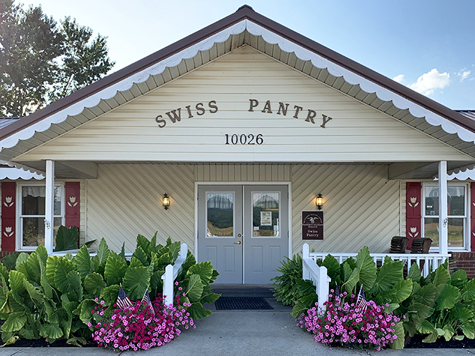 The Swiss Pantry's charming cottage exterior welcomes you with colorful flowers and a promise of homemade goodness inside.