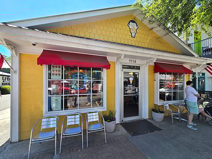 That cheerful yellow facade practically winks at you, promising sweet treasures behind those welcoming red awnings.
