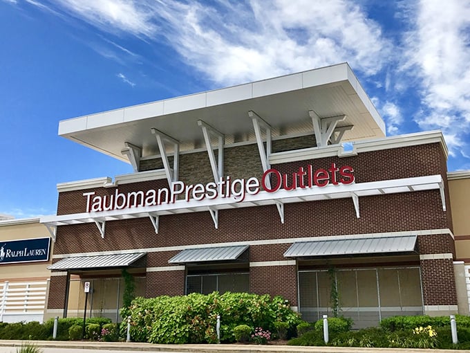 The grand entrance to Taubman Prestige Outlets beckons like a siren song to your wallet. Brick, glass, and the promise of bargains await!