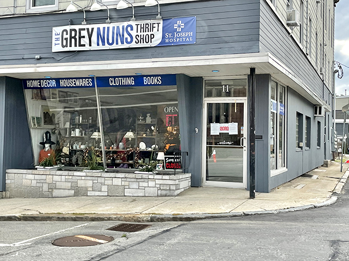 The Grey Nuns Thrift Shop: A blue-gray corner building with large windows showcasing treasures within. Home decor, housewares, and clothing await bargain hunters!