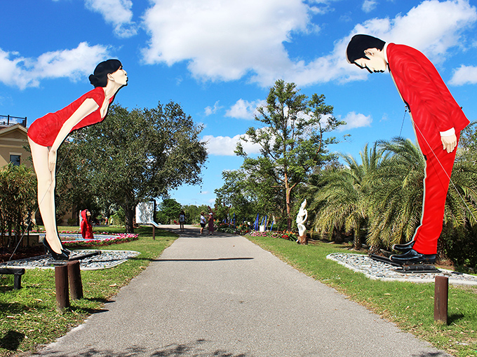 The famous bowing figures create a whimsical entrance, like formal greeters at the world's most artistic garden party.
