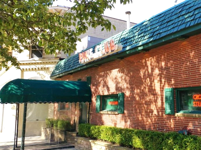 The Pine Club's iconic green awning and brick facade - a Dayton landmark that's been turning first-timers into regulars since before color TV was a thing.