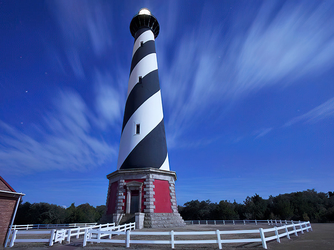 Standing tall against a brilliant blue sky, Cape Hatteras Lighthouse's iconic black and white spiral stripes create a mesmerizing optical illusion that's impossible to resist photographing.