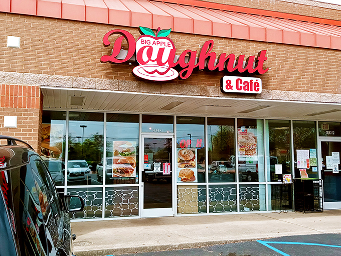 The bright red Big Apple Donuts sign promises sweet salvation for morning commuters. One bite and your day is transformed!