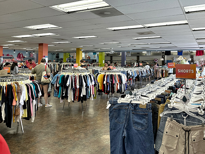 Rows of carefully curated clothes stretch like a rainbow of second chances and style possibilities.