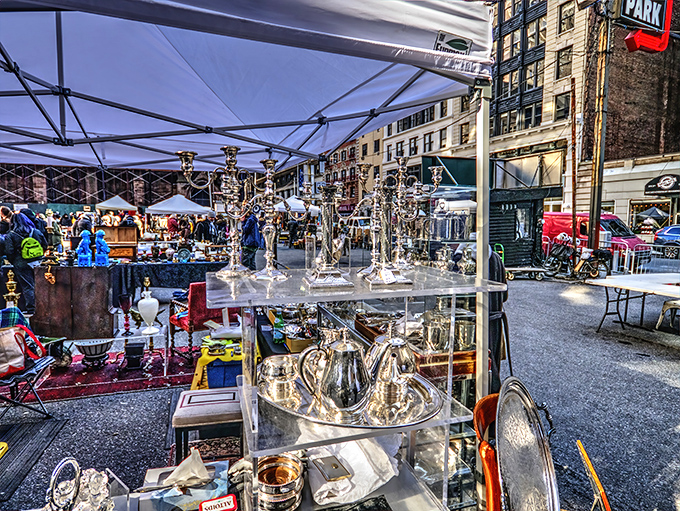 Silver treasures gleam under city skies - someone's grandmother's tea set awaits its next loving home.