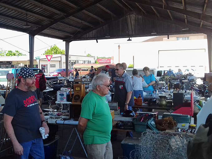 Serious shoppers gather under the shelter, hunting for bargains with the focus of seasoned detectives.