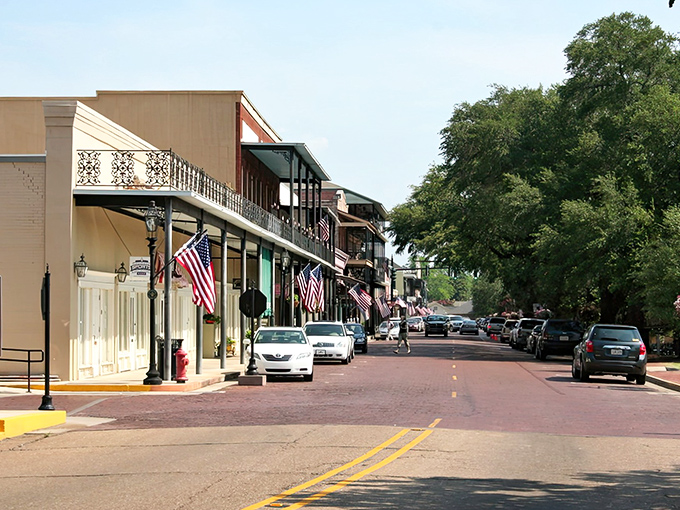 Tree-lined streets create natural tunnels of shade where every storefront holds a piece of Natchitoches history.
